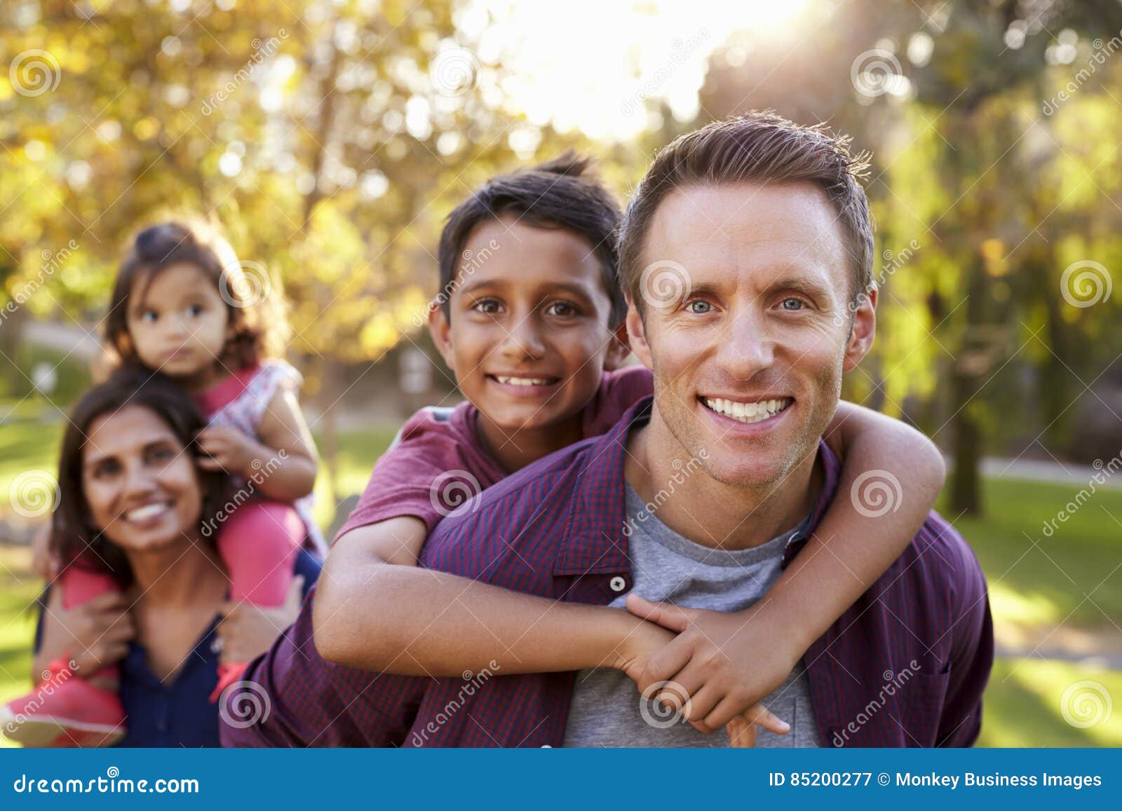 Mixed Race Parents Carry Kids Piggyback, Selective Focus Stock Image ...