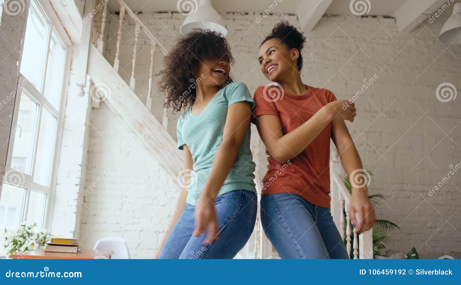 Mixed Race Young Beautiful Girls Dancing On A Bed Together Having Fun