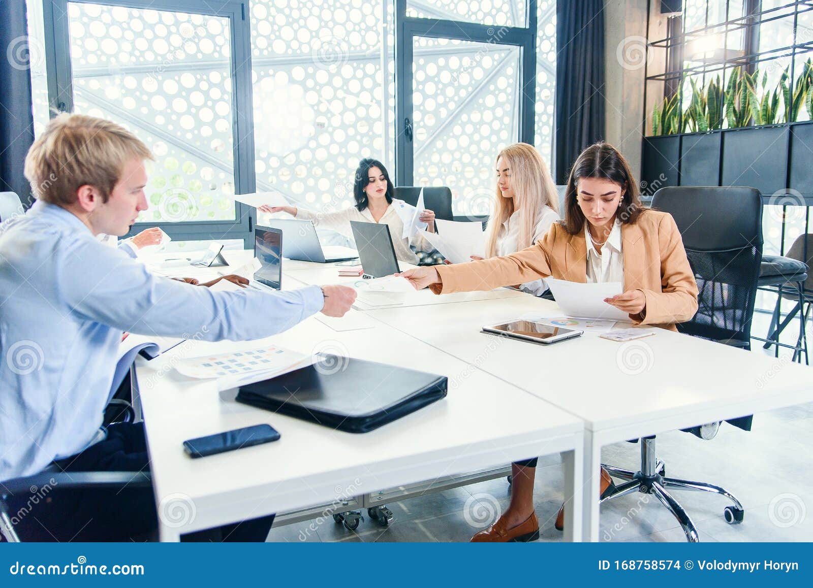 Mixed Races Coworkers Analysing Different Business Papers and Working ...