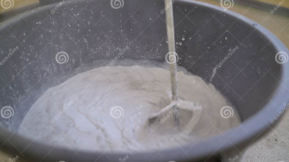 The Primer is Mixed in a Large Bucket Using a Construction Mixer. the ...