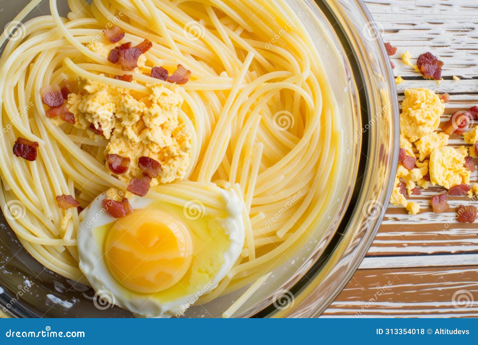Mixing Bowl with Whisked Eggs Next To a Pile of Spaghetti and Bacon ...
