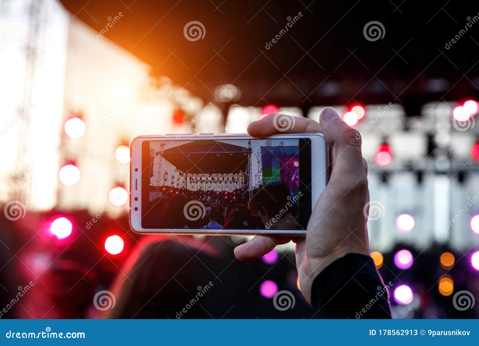 Mobile Phone in Hands at a Music Show. Using a Smartphone Concept ...