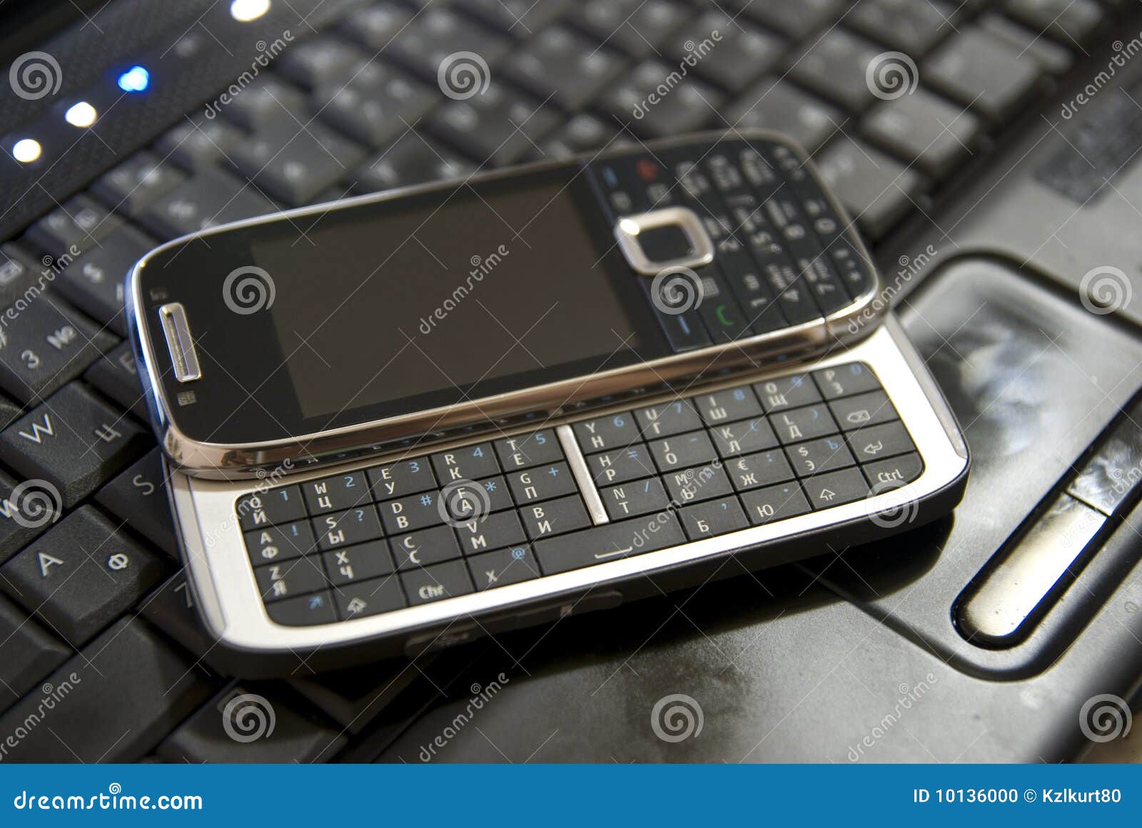 Mobile phone on a laptop. stock photo. Image of design - 10136000