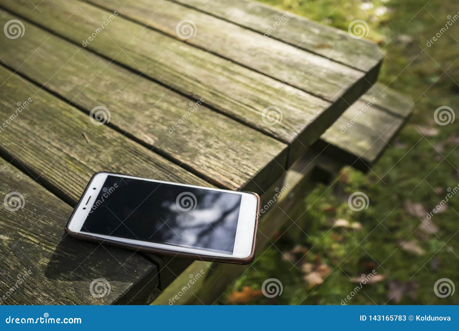 Mobile Phone is Lying Dangerously on the Edge of a Wooden Table ...