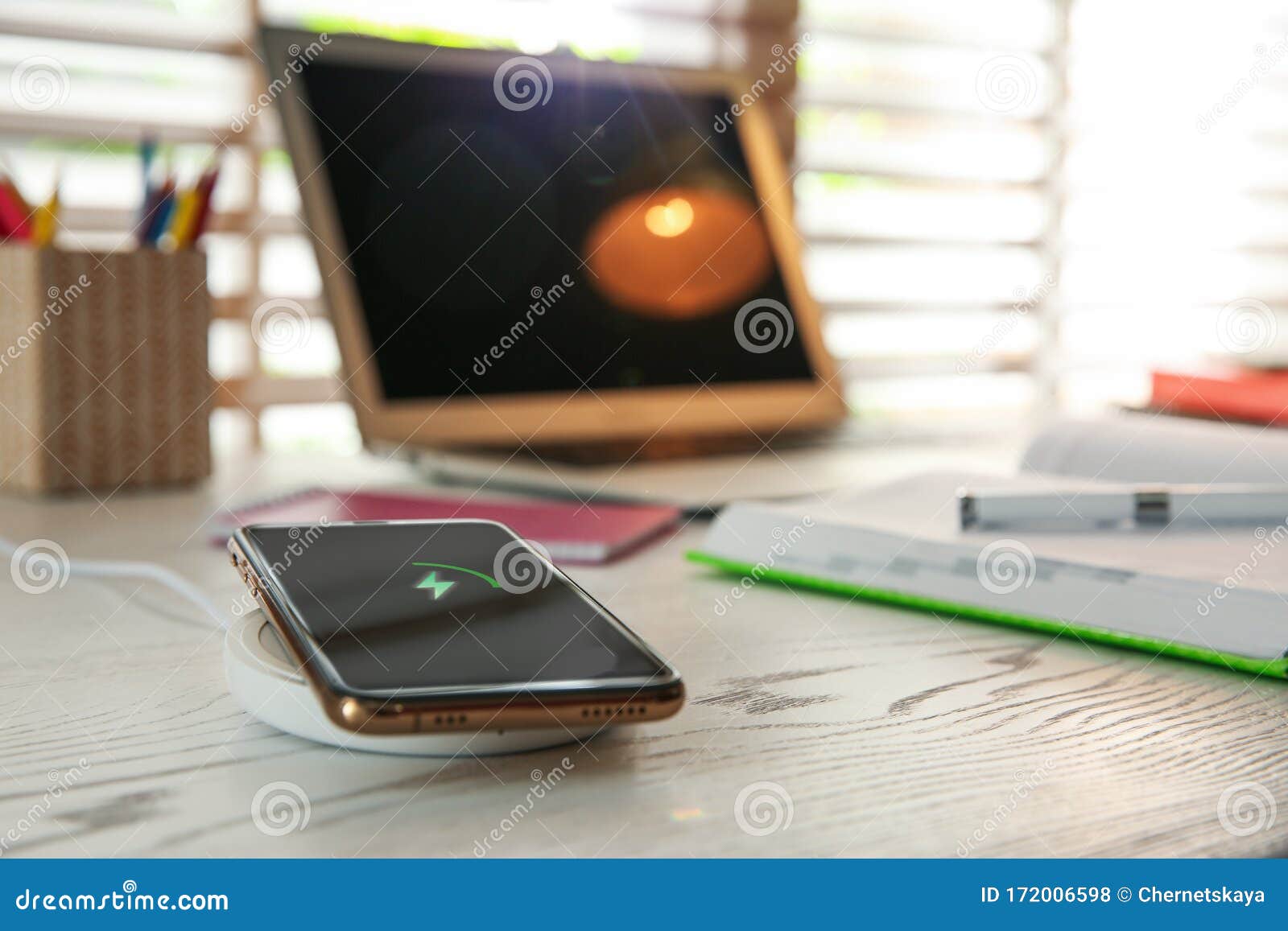 Mobile Phone with Wireless Charger on Wooden Table. Modern Workplace ...
