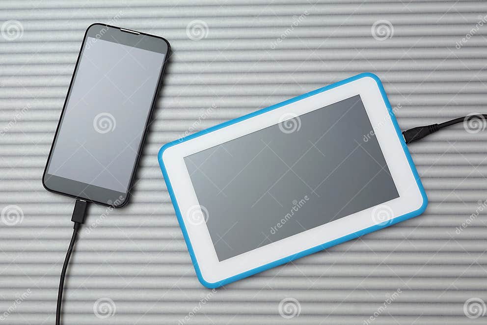 Mobile Smart Phone and Tablet Pc Charging on Silver Desk Stock Photo ...