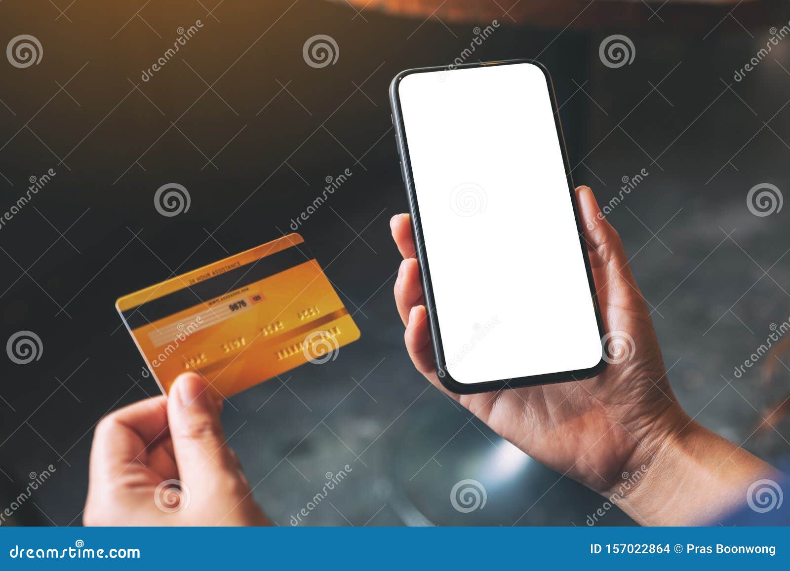 A Hands Holding Credit Card and a Black Mobile Phone with Blank Desktop ...