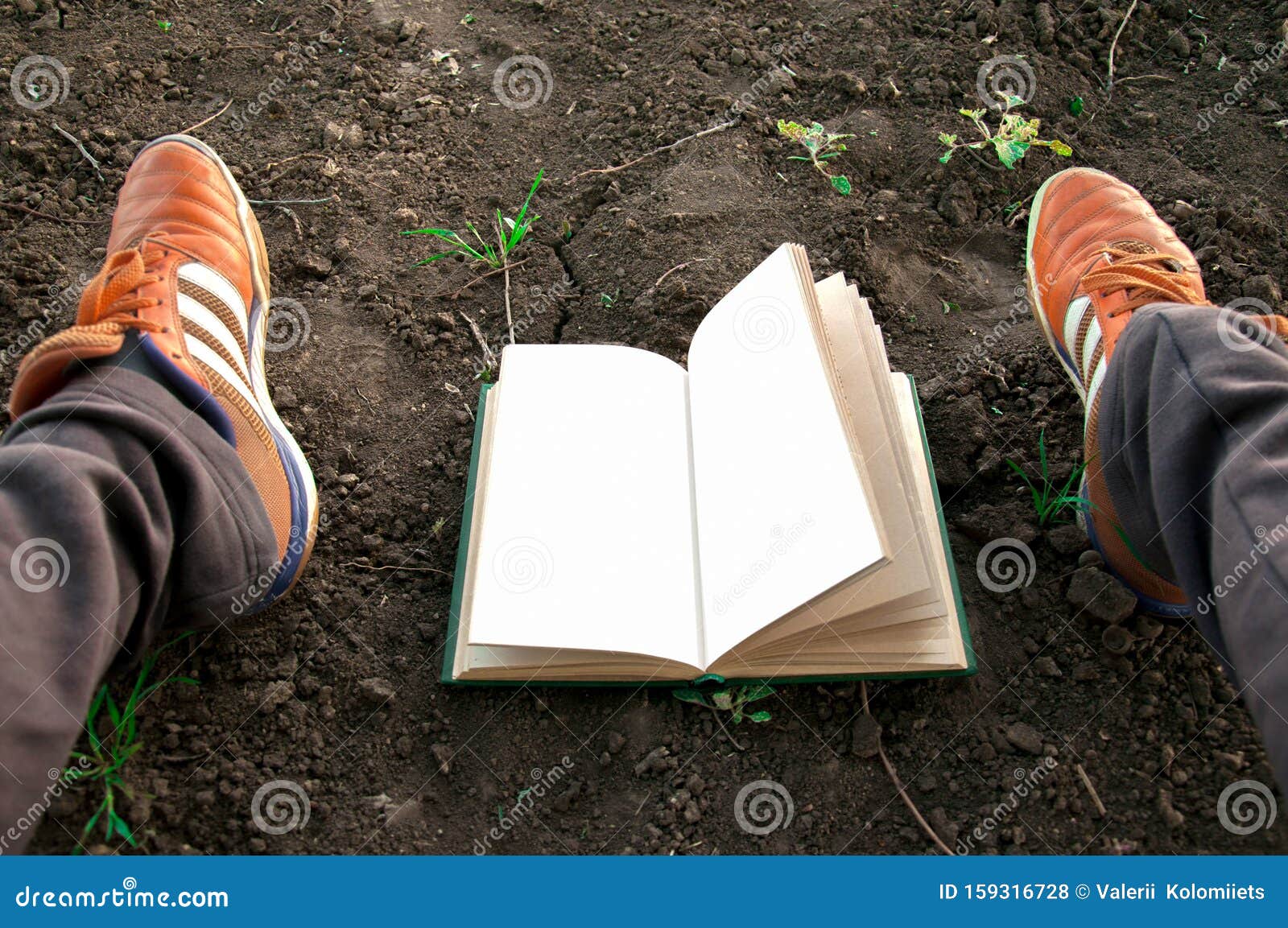 A Man Sits on the Ground and in Front of Him Lies an Open Book on the ...