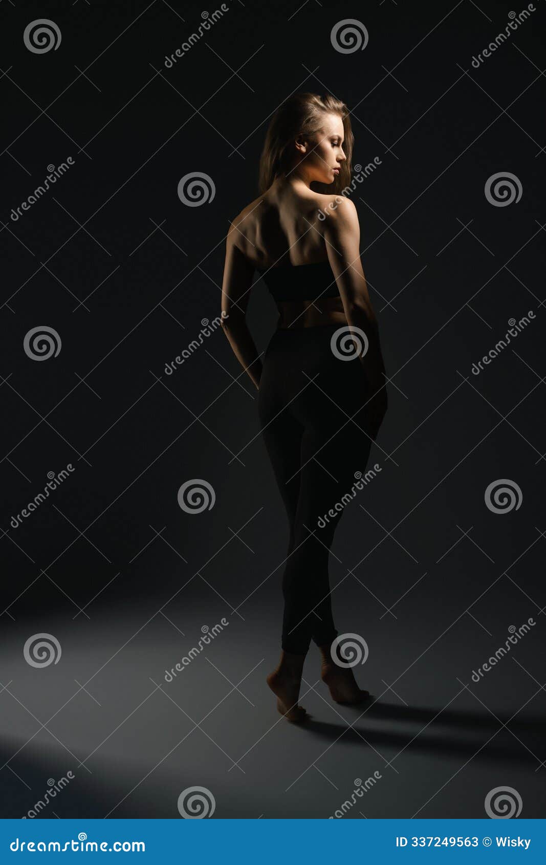 A Model Poses Gracefully in a Dimly Lit Studio during a Photoshoot ...