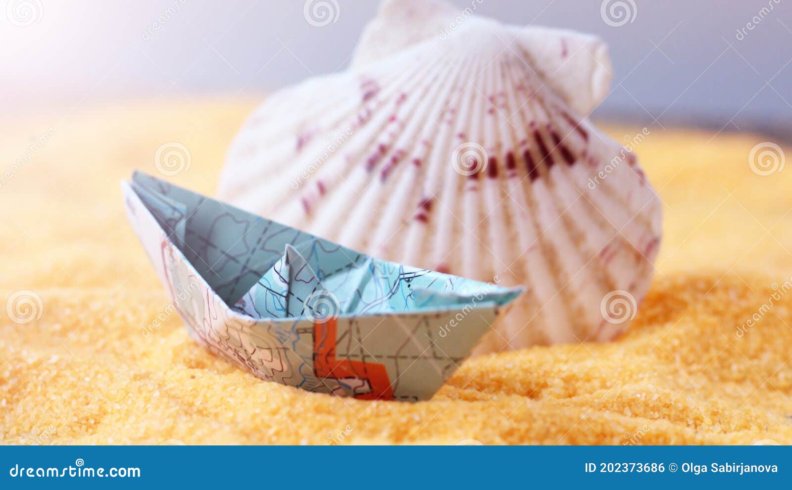 Model of a Ship from a Paper Map on the Sand and a Seashell Stock Photo ...
