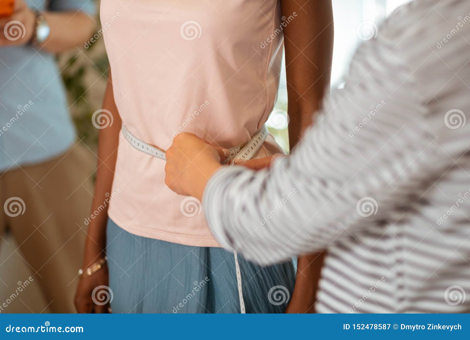 Female Tailor Measuring a Models Waist with a Measuring Tape Stock ...