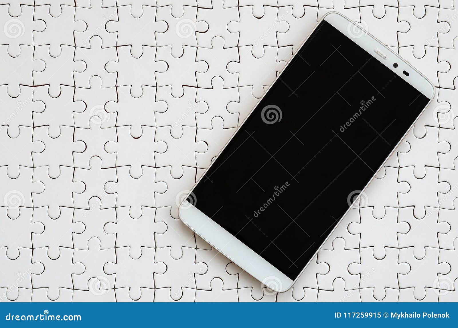 A Modern Big Smartphone with a Touch Screen Lies on a White Jigsaw ...