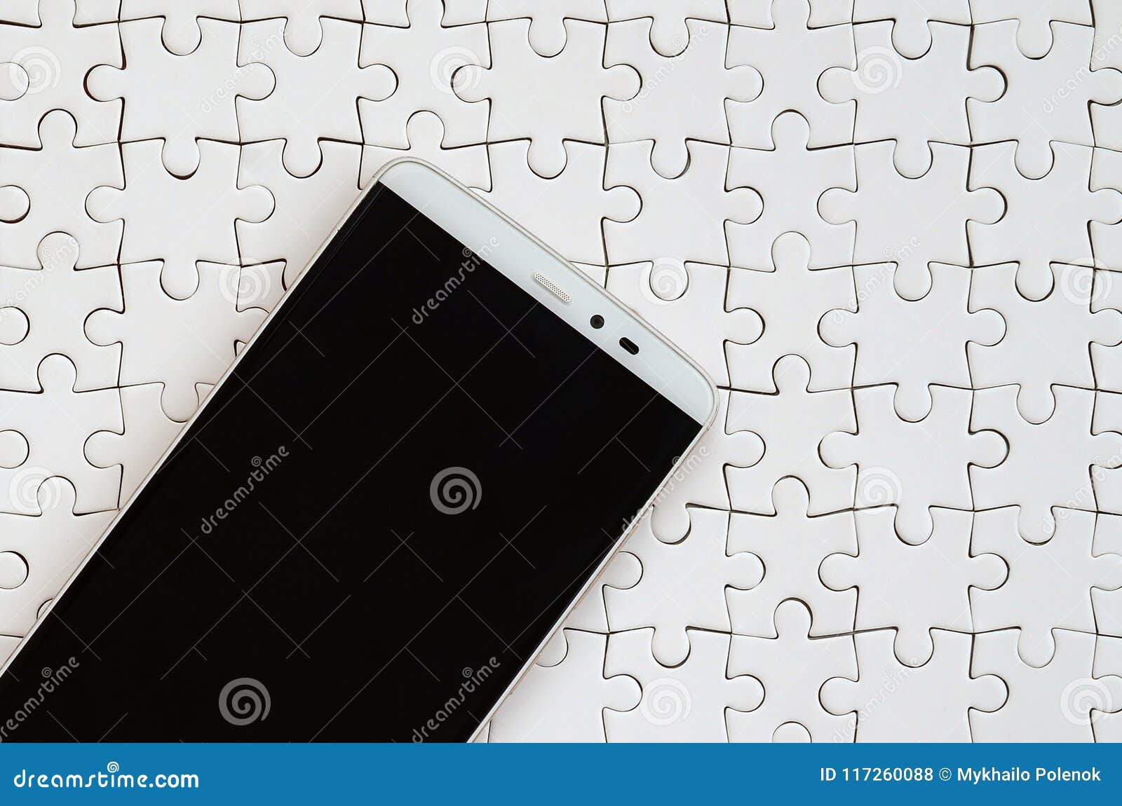 A Modern Big Smartphone with a Touch Screen Lies on a White Jigsaw ...