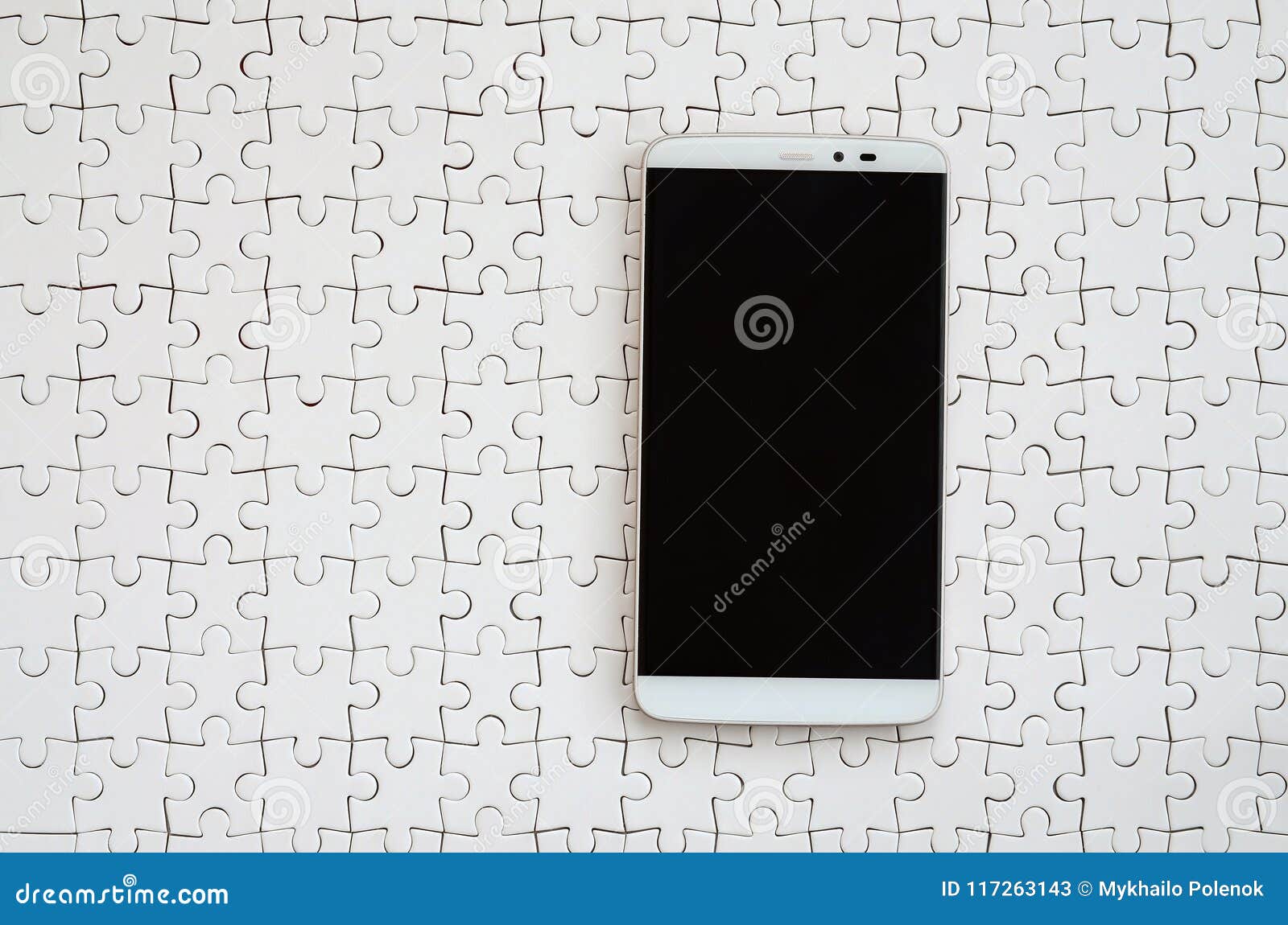 A Modern Big Smartphone with a Touch Screen Lies on a White Jigsaw ...