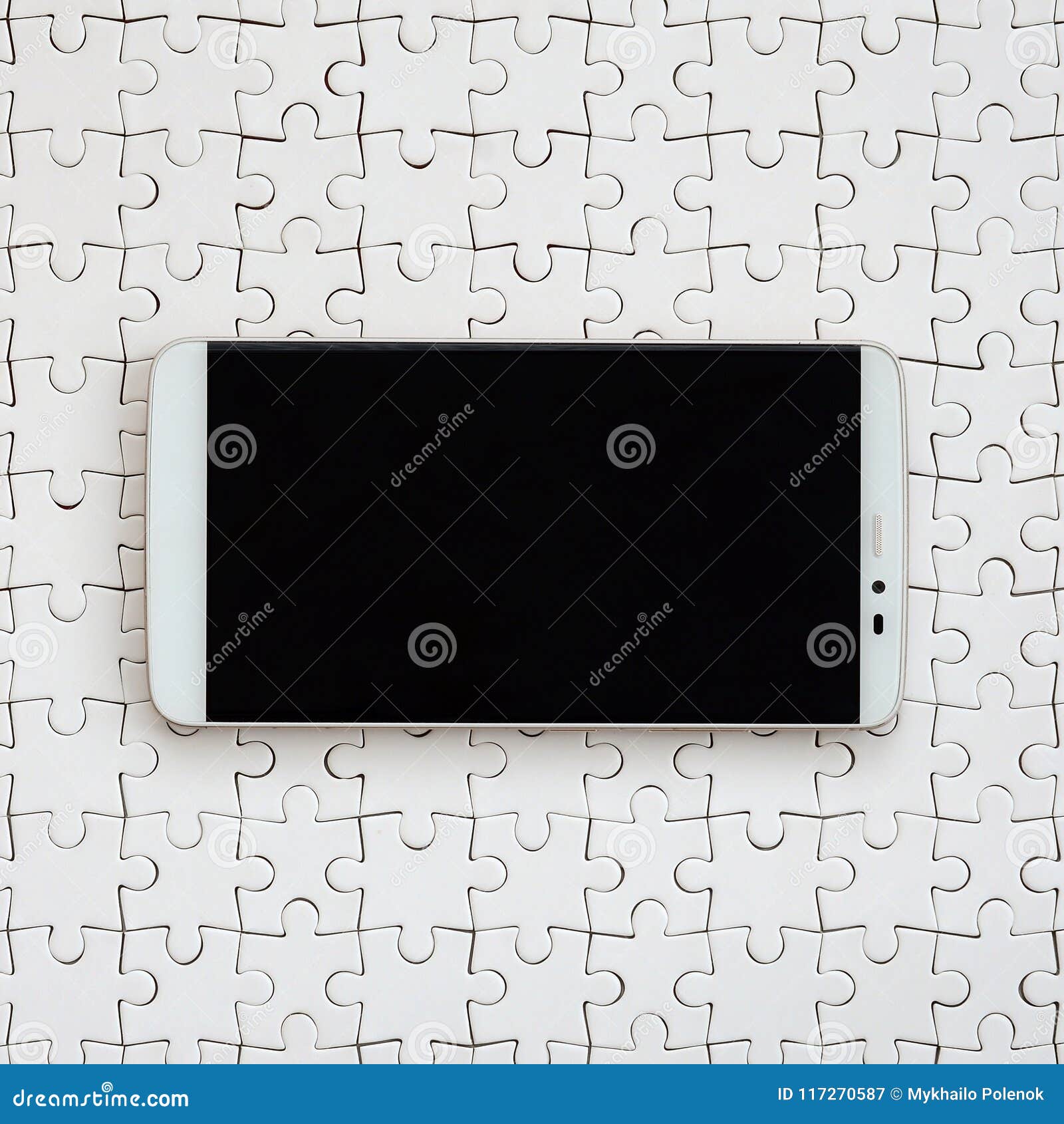 A Modern Big Smartphone with a Touch Screen Lies on a White Jigsaw ...