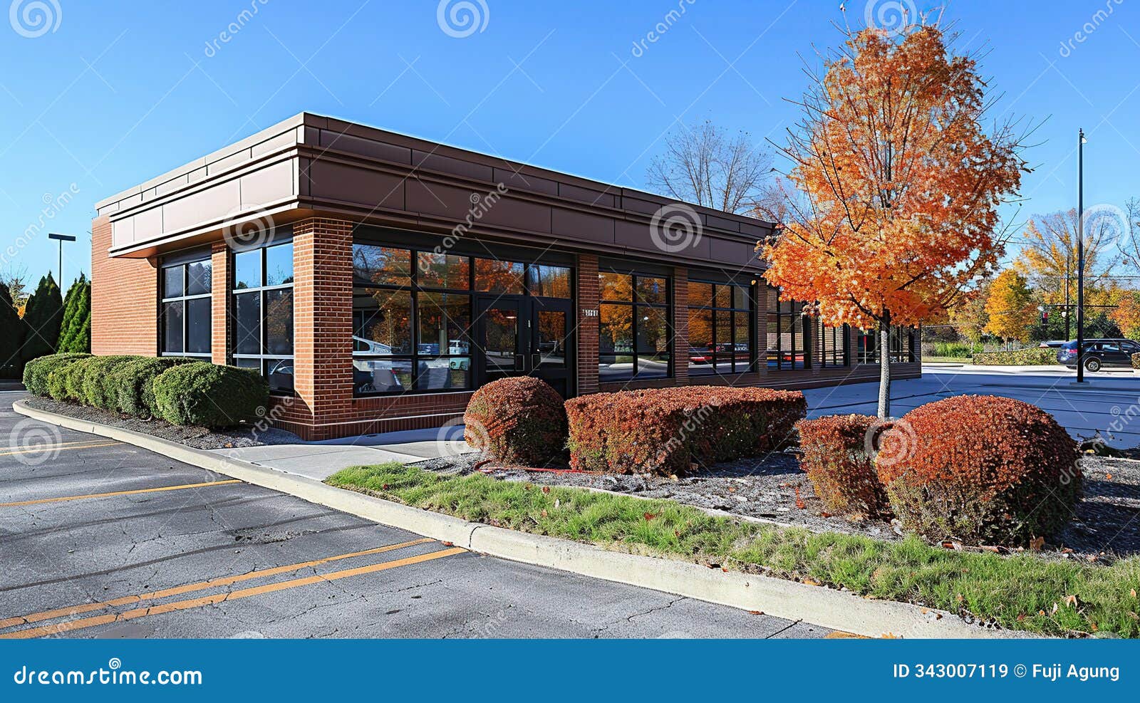 A Modern Brick Building with Large Windows, a Paved Parking Lot, and a ...