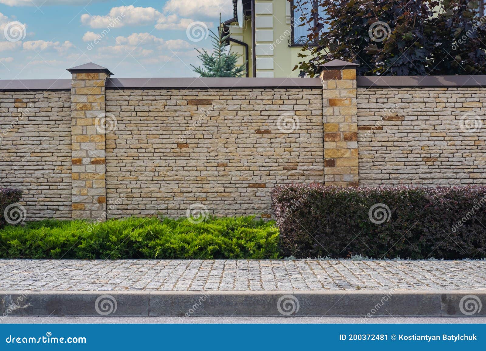 Modern Brick Pattern of Light Stone Fence Wall with Posts in Front of a ...