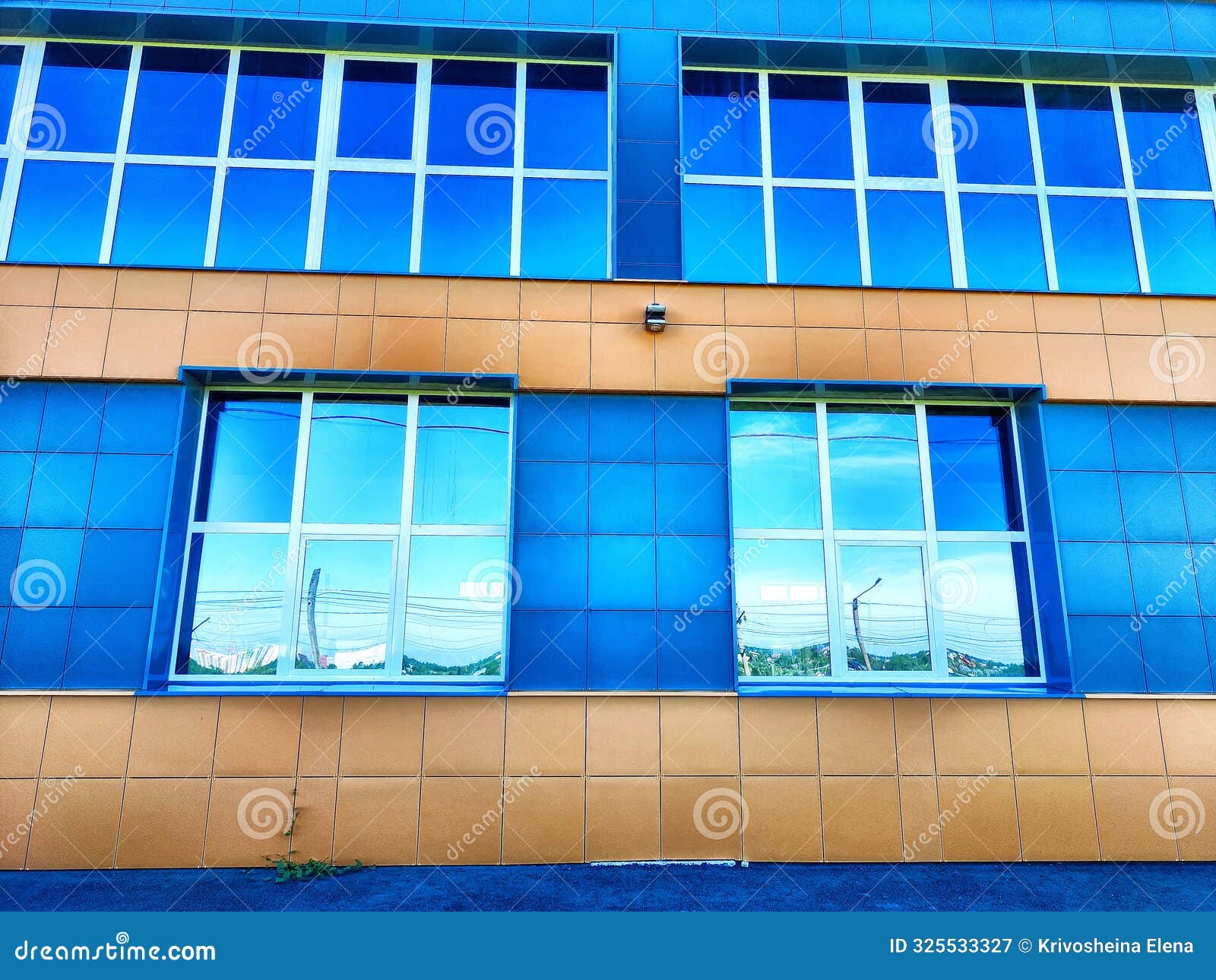 A Modern Building Facade with Blue Glass Windows and Beige Tiles Stock ...