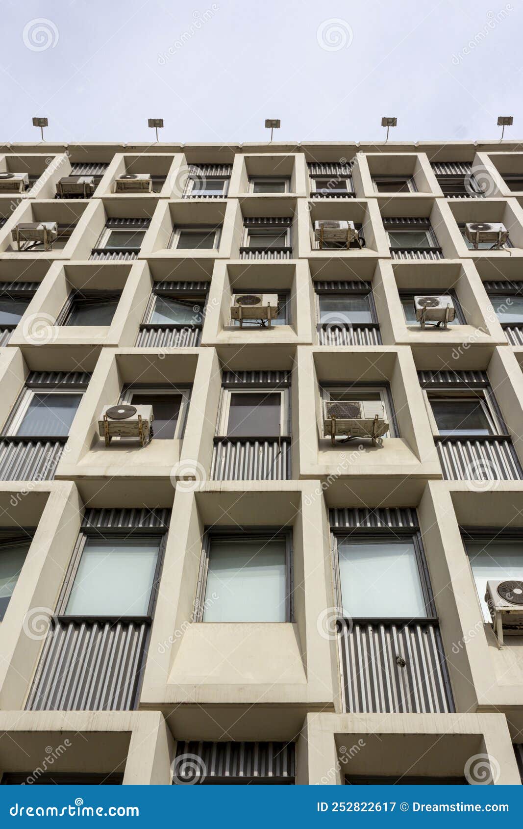 A Modern Building with a Yellow Facade and Lots of Air Conditioners ...