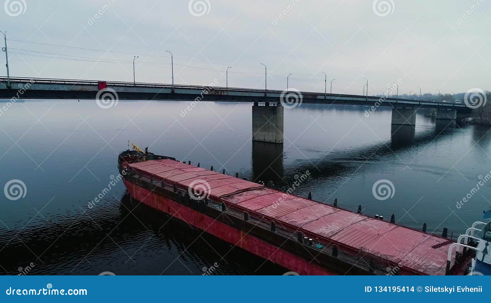 Modern Cargo Ship Going Under the Bridge on the Wide River Stock ...