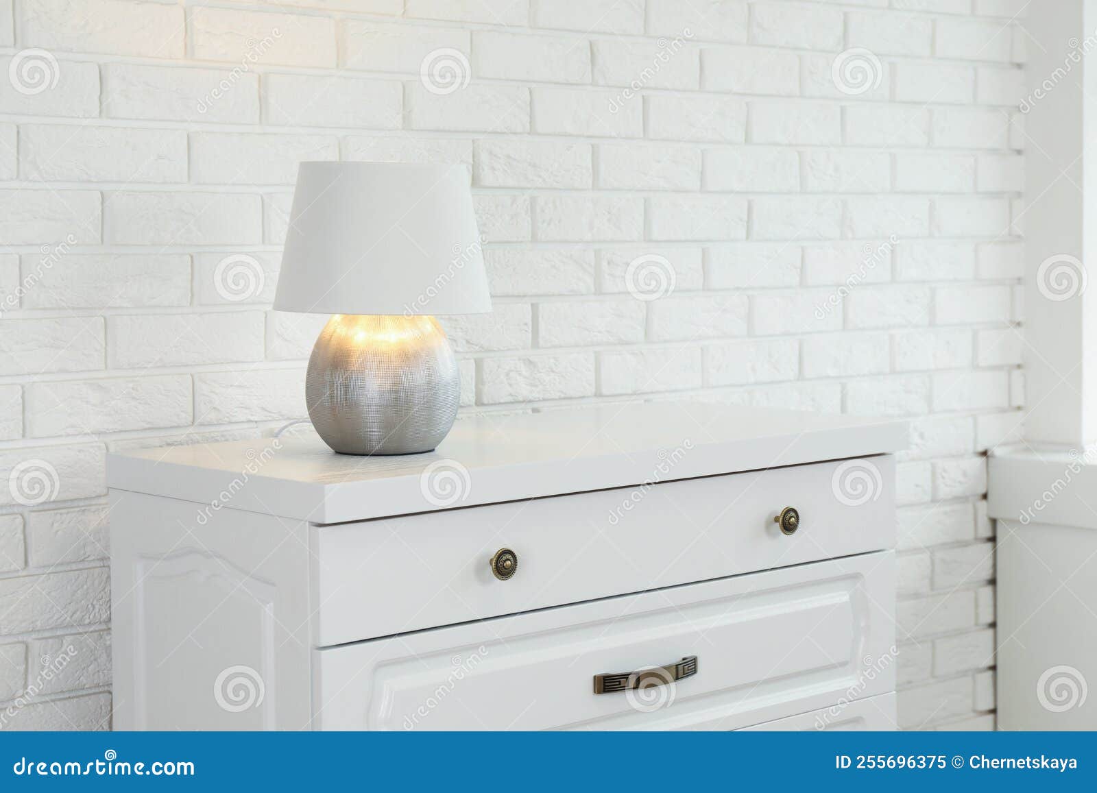 Modern Chest of Drawers with Lamp Near White Brick Wall Stock Image ...
