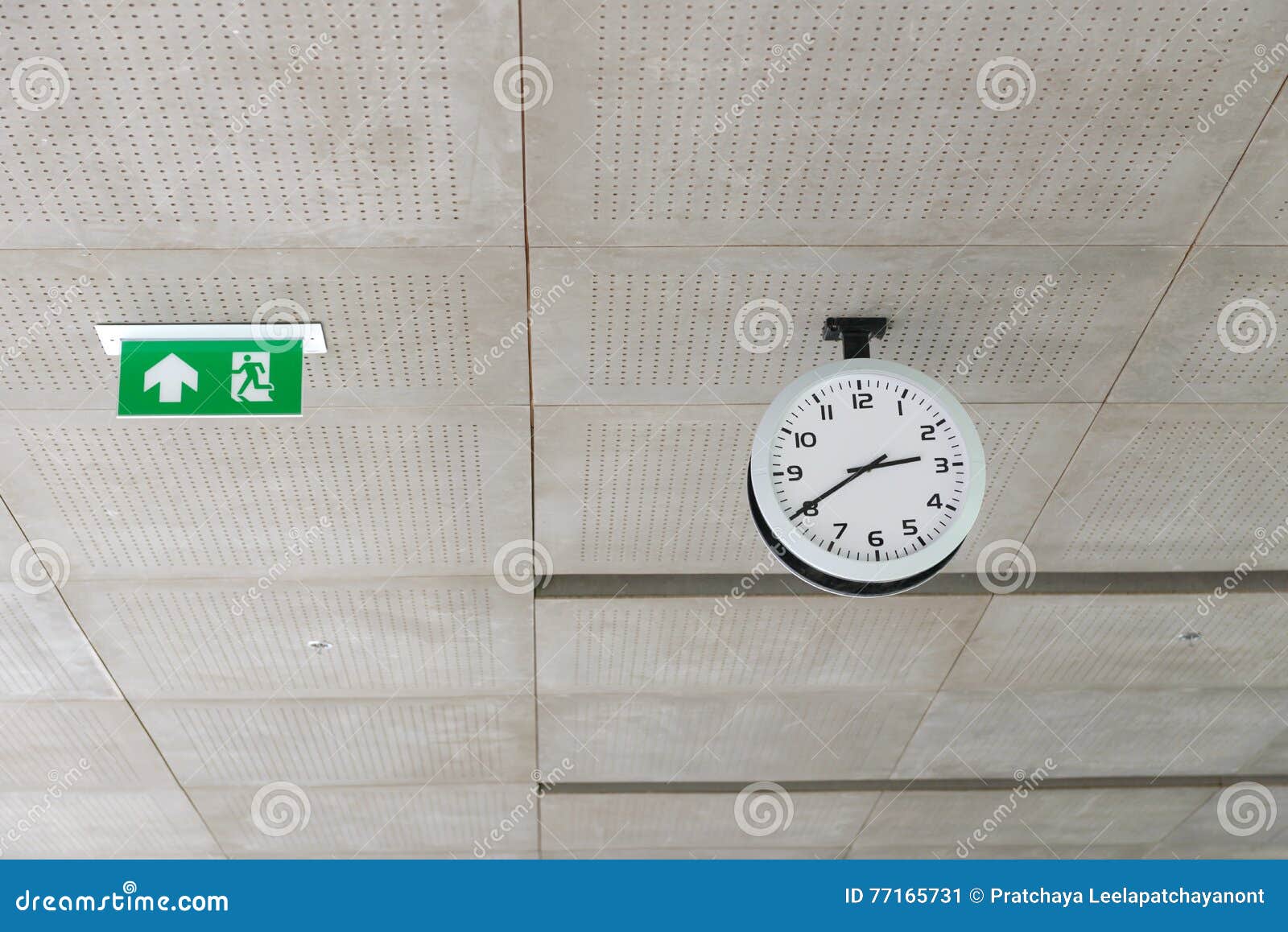 Modern Circle Clock and Exit Sign Hang on Ceiling Under Building Stock ...