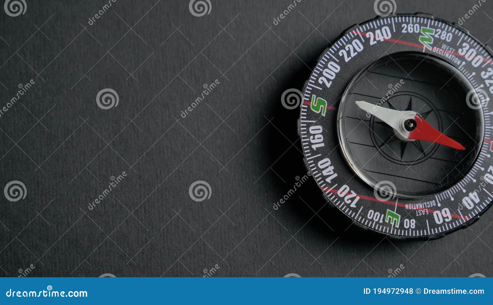 A Modern Compass Lying On A Black Desk With A Red Arrow That Shows The Direction Concept Of