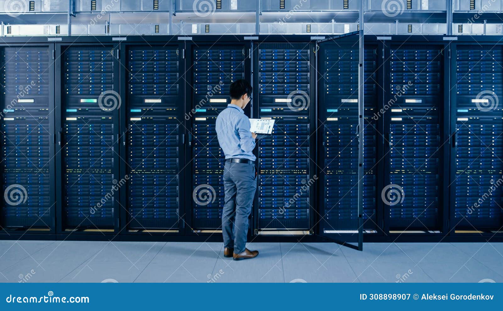 In the Modern Data Center: it Engineer Standing beside Open Server Rack ...