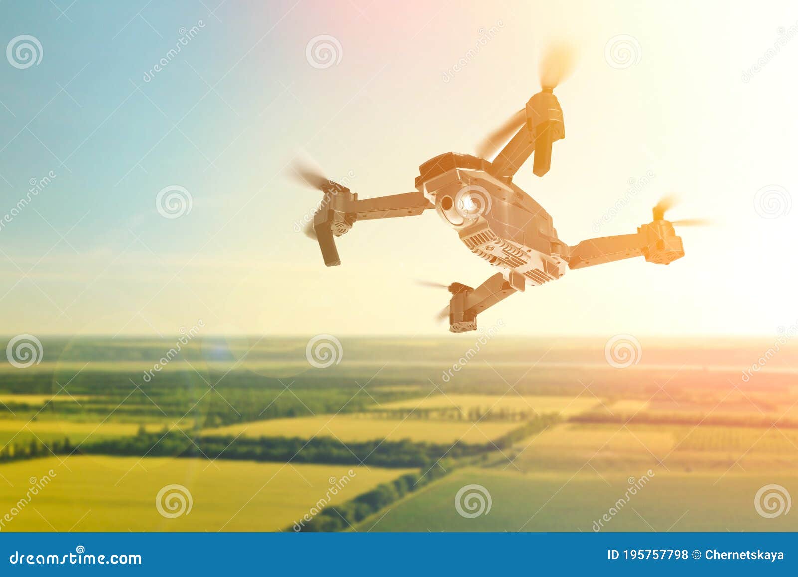 Modern Drone Flying Over Fields on Sunny Day. Stock Photo - Image of ...
