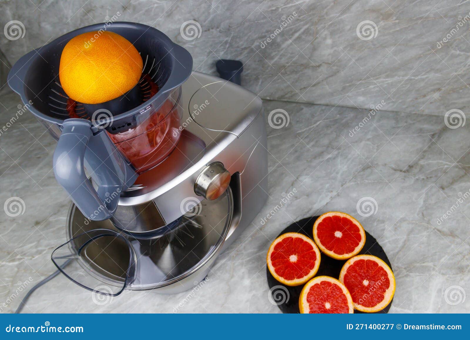 Modern Electric Juicer and Grapefruits on Kitchen Table. Preparing ...