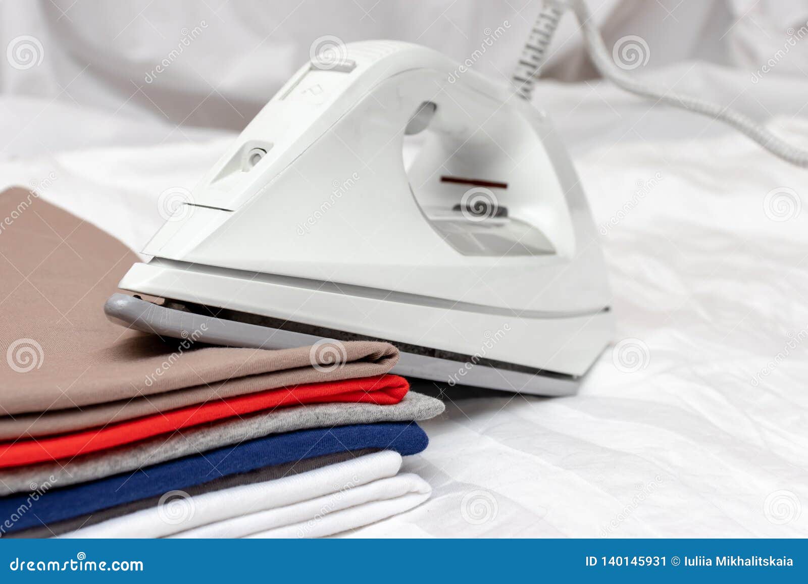 Modern Electrical White Iron on a Stack of Clothes Close Up - Ironing ...
