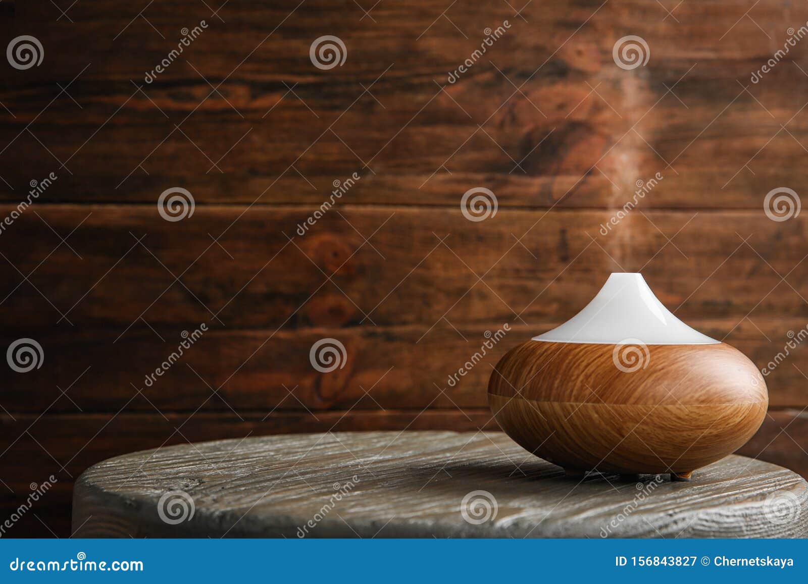 Modern Essential Oil Diffuser on Wooden Table Against Brown Background ...