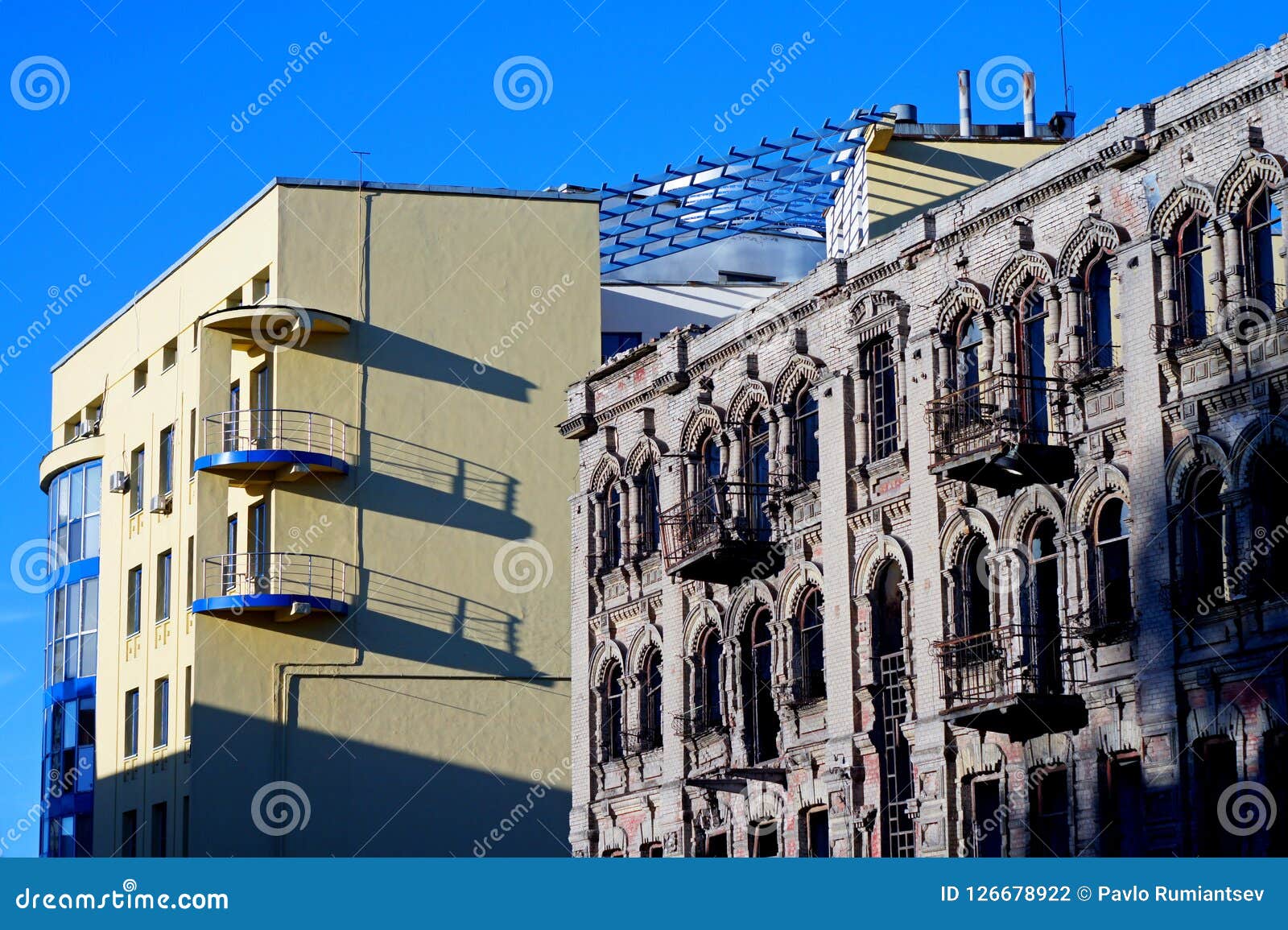 Modern and Facade of an Old Dilapidated Building Against a Blue Sky ...
