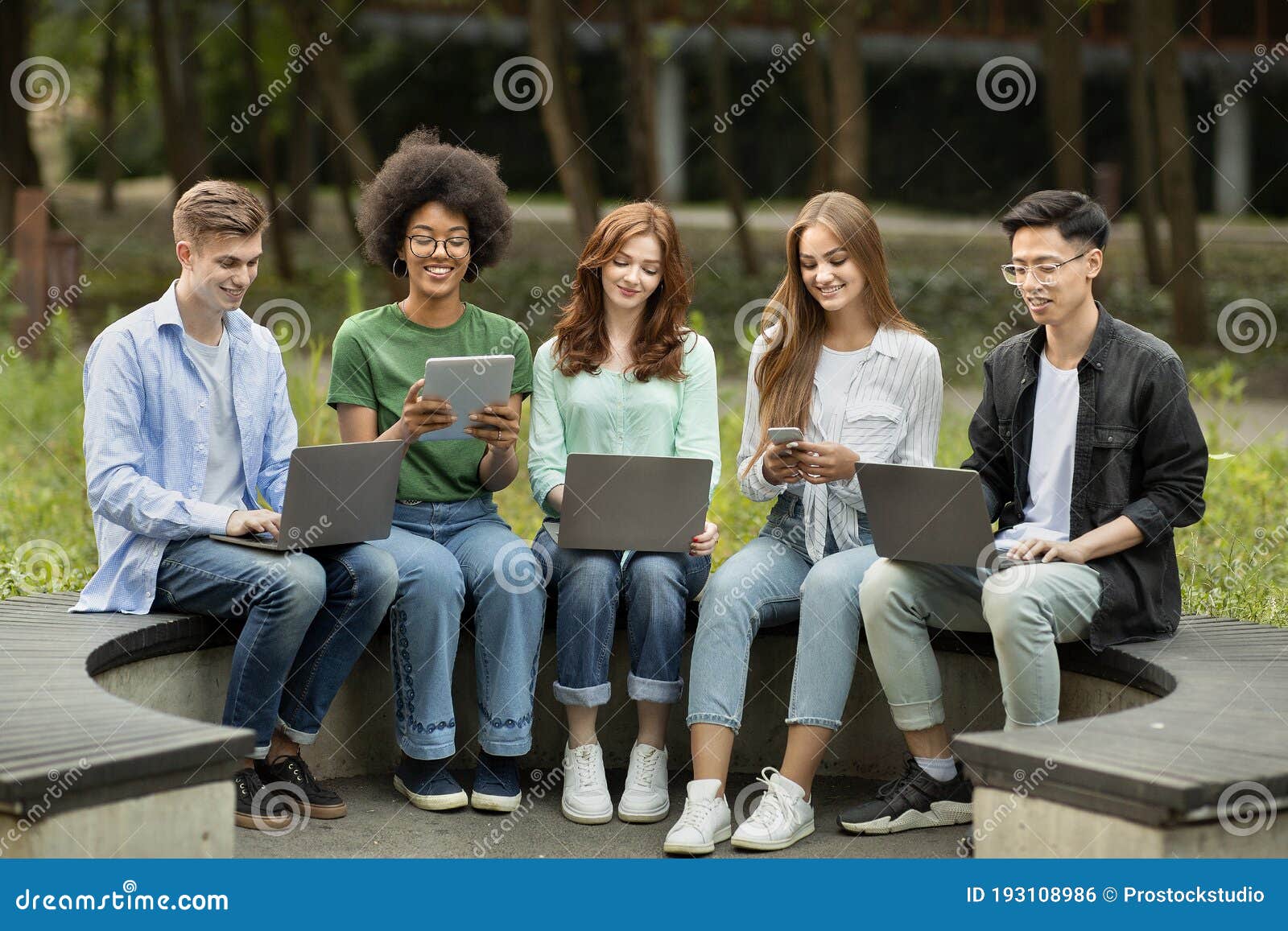 Modern Gadgets for Study. College Students Sitting Outdoors with ...