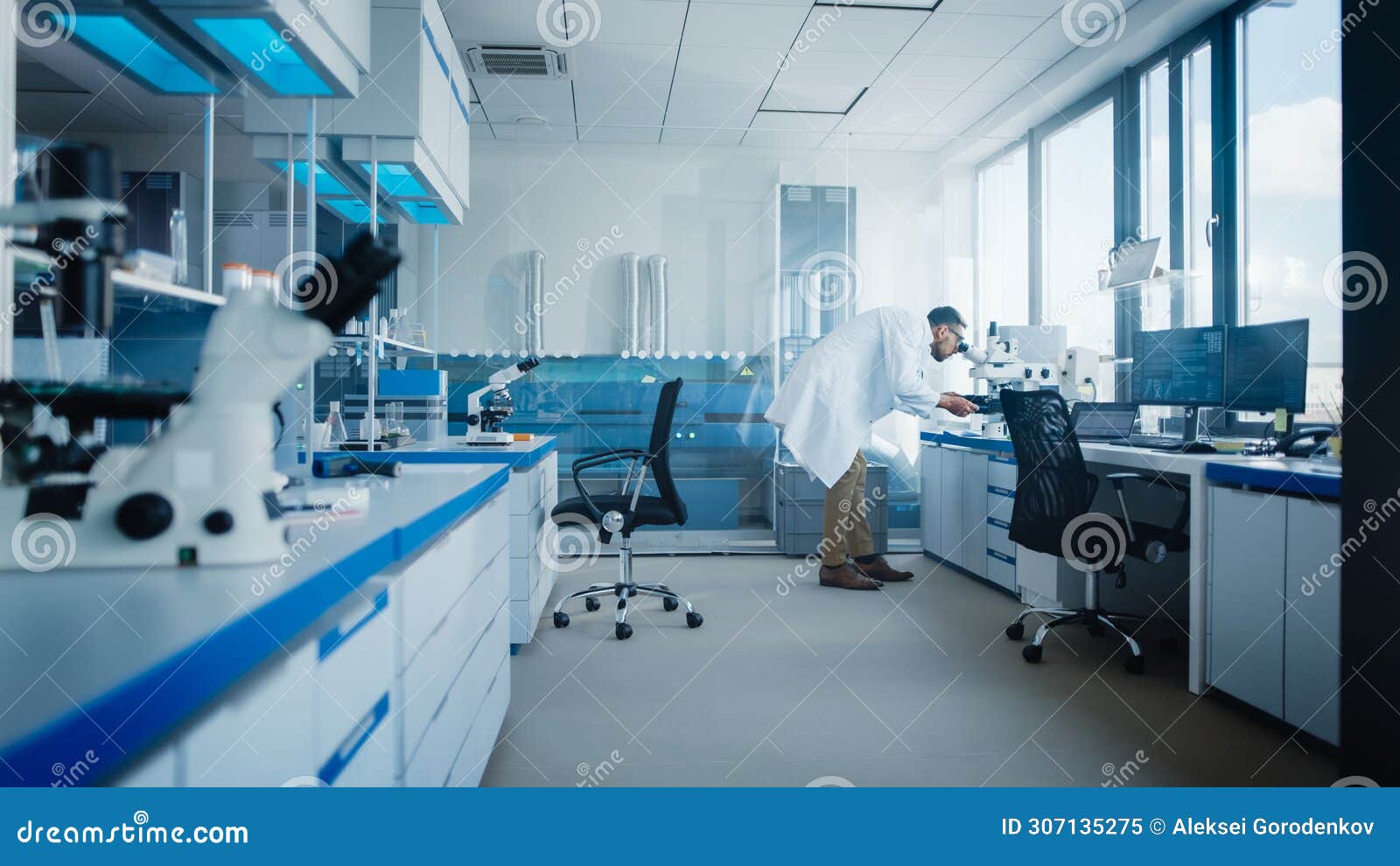 Modern Medical Research Laboratory with Male Scientist Looking Under ...