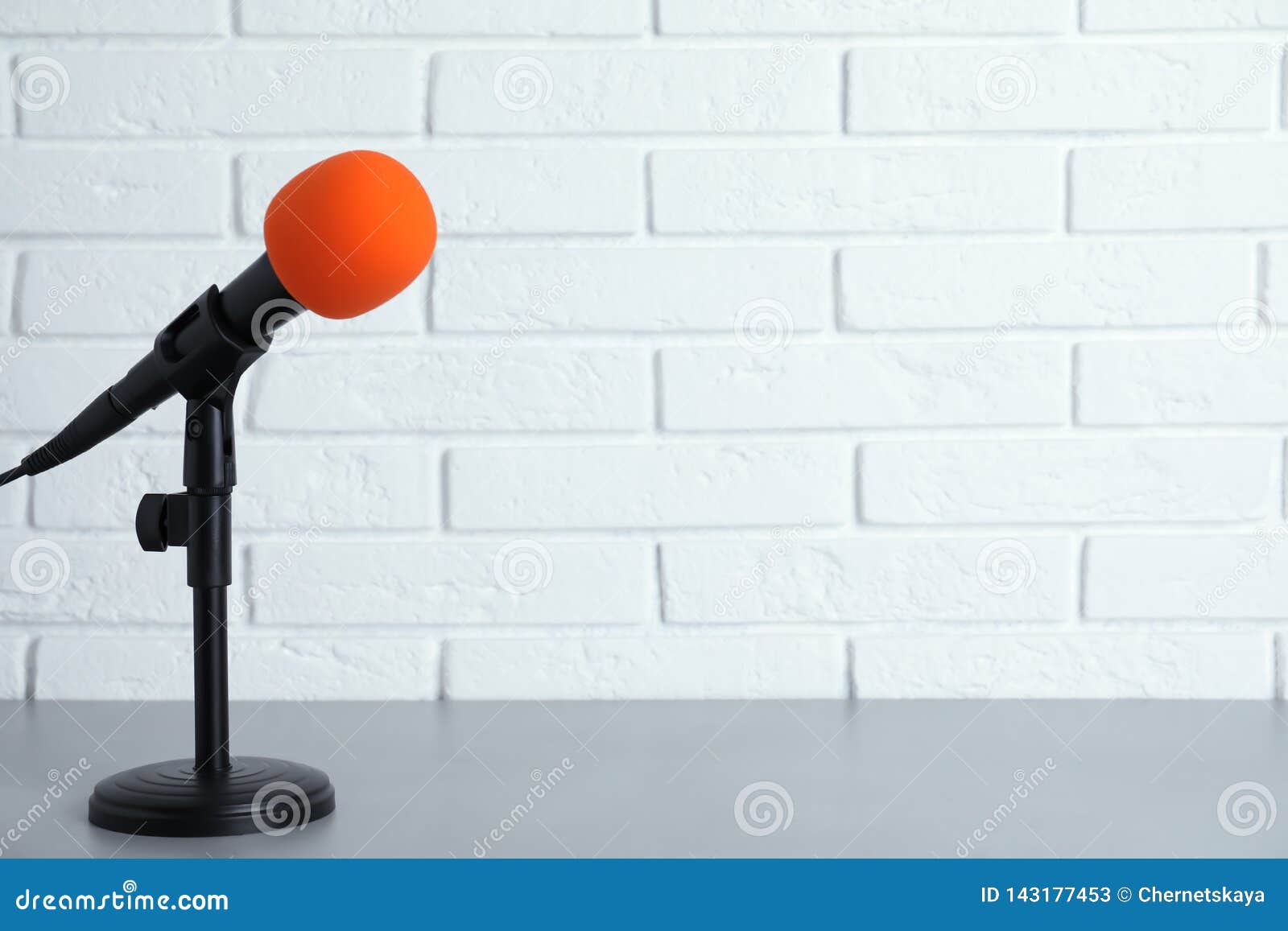 Modern Microphone on Table Near Brick Wall Stock Image - Image of ...