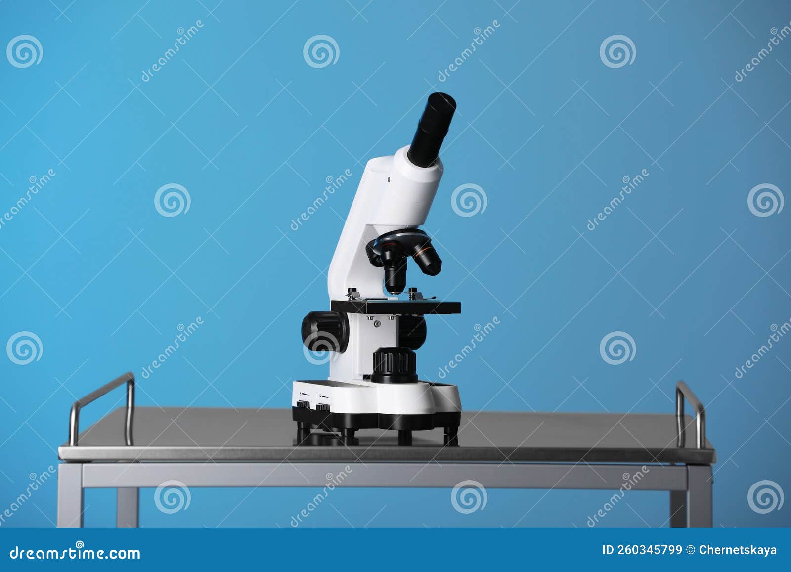 Modern Microscope on Metal Table Against Blue Background Stock Image ...