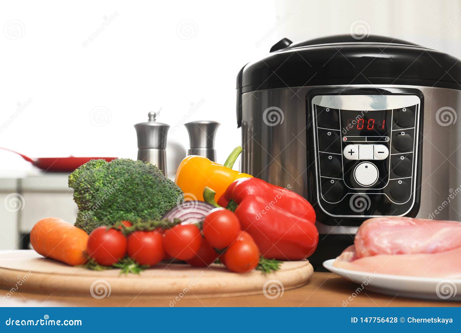 Modern Multi Cooker and Ingredients on Wooden Table in Kitchen. Stock ...