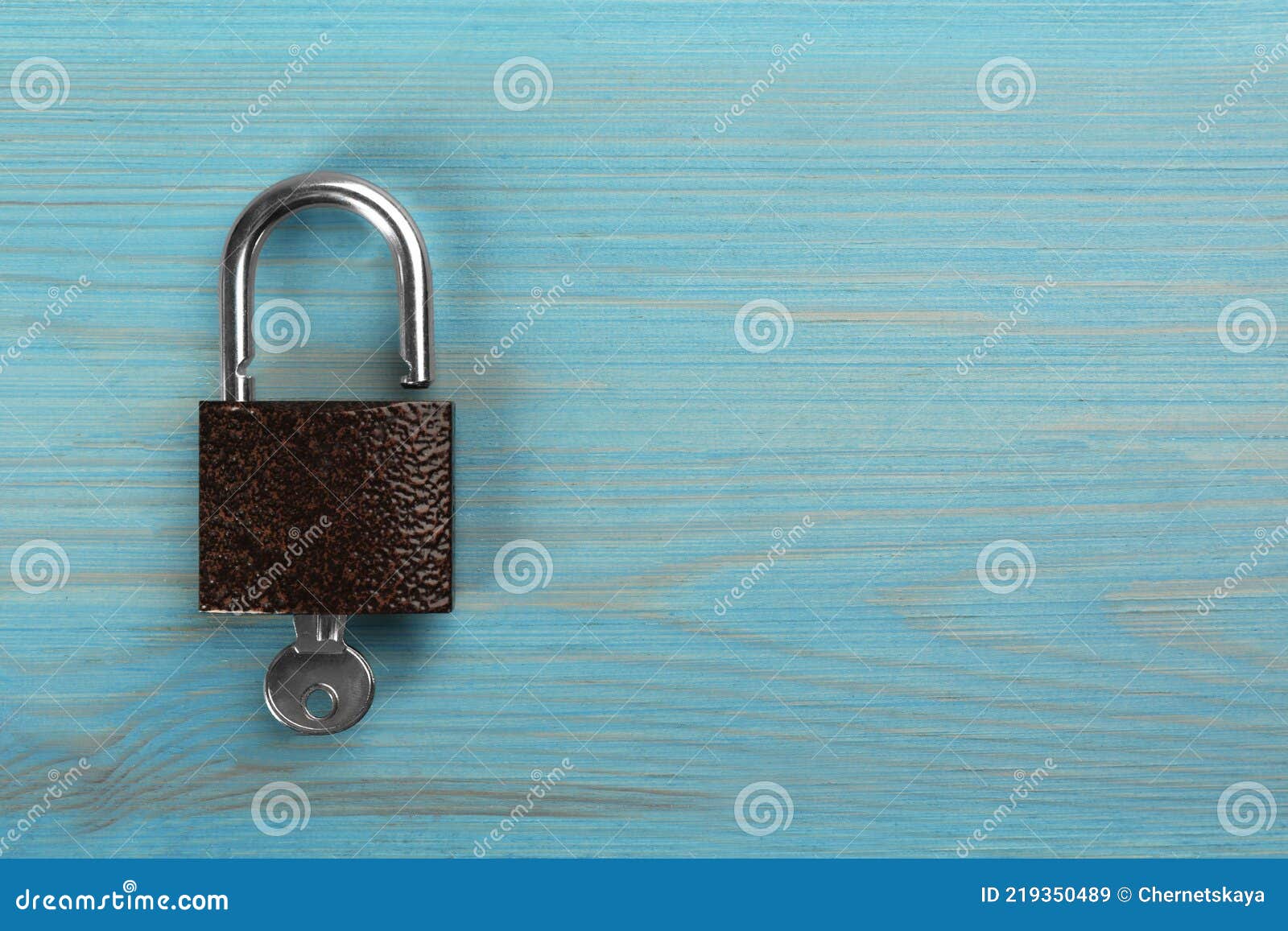 Modern Padlock with Key on Light Blue Wooden Table, Top View. Space for ...