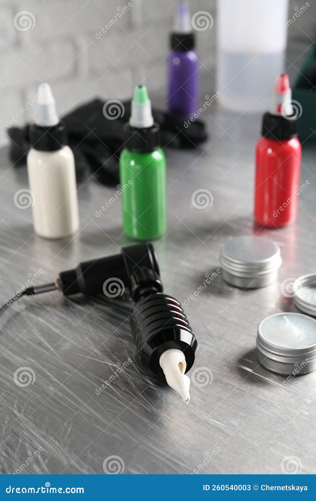 Modern Professional Tattoo Machine, Colorful Inks and Ointment on Table ...