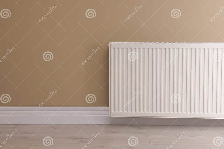 Modern Radiator on Beige Wall, Space for Text. Central Heating System ...