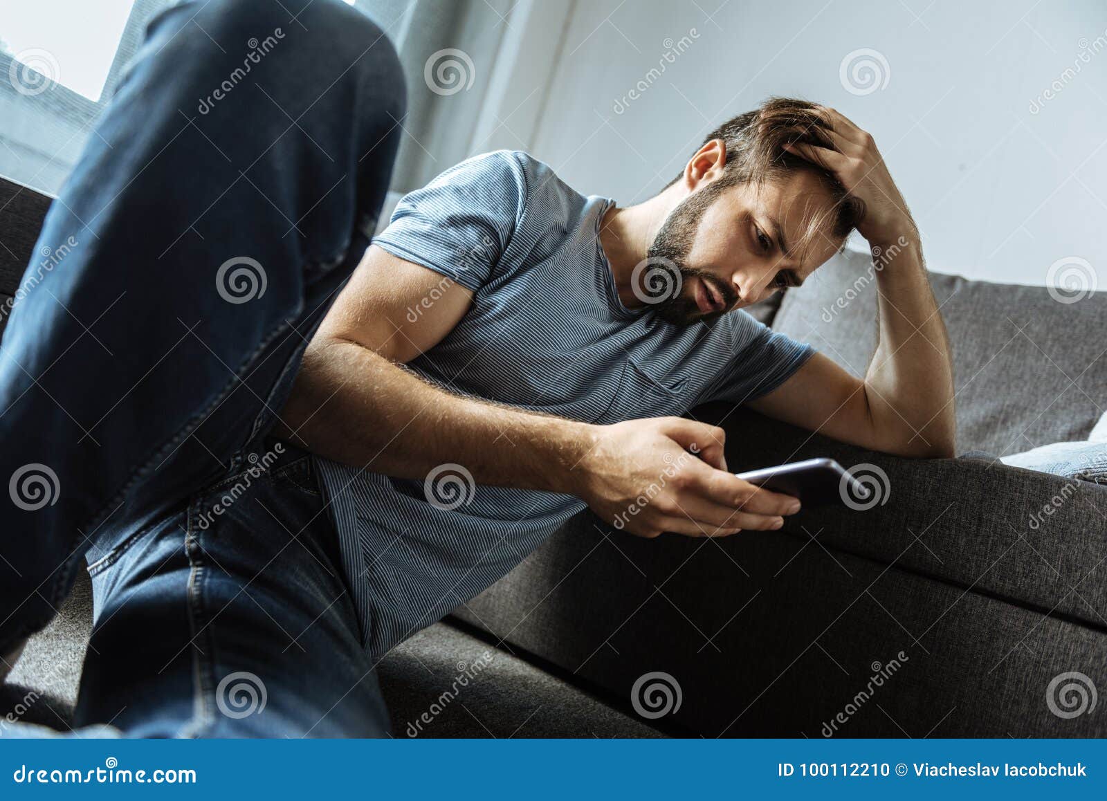 Depressed Handsome Man Using His Smartphone Stock Photo - Image of ...
