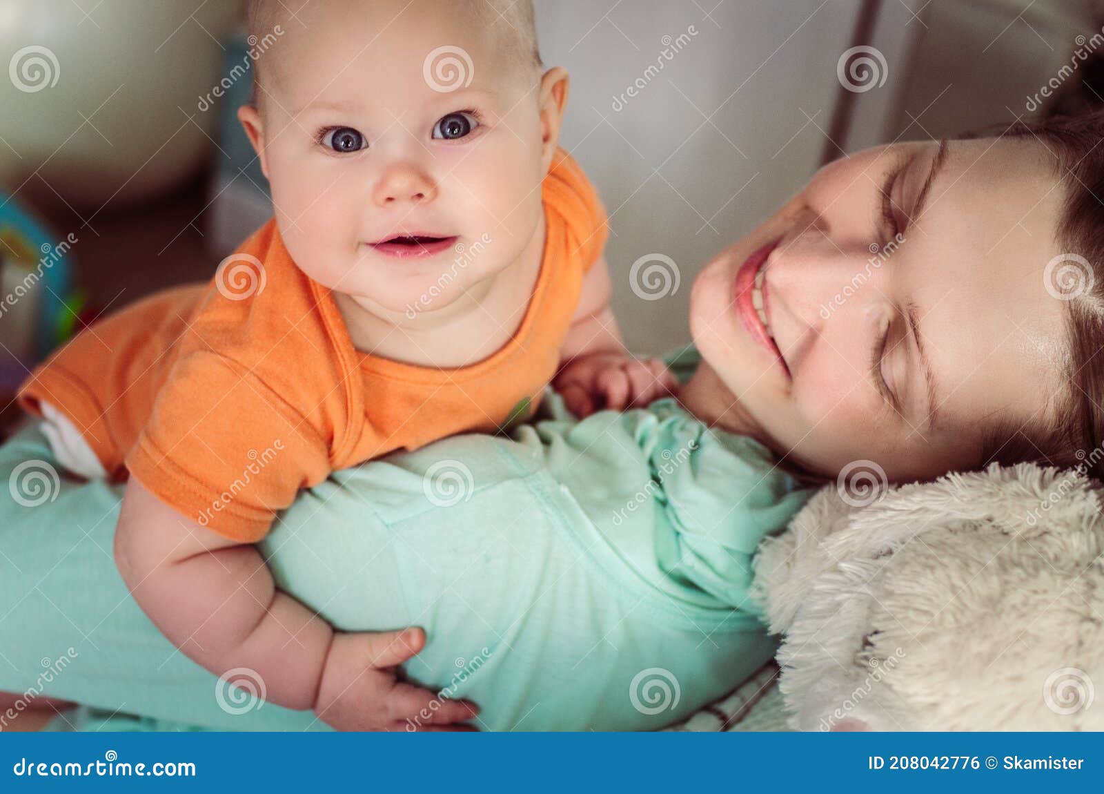 Mom and Baby are Resting and Smiling while Sitting on the Couch Stock ...