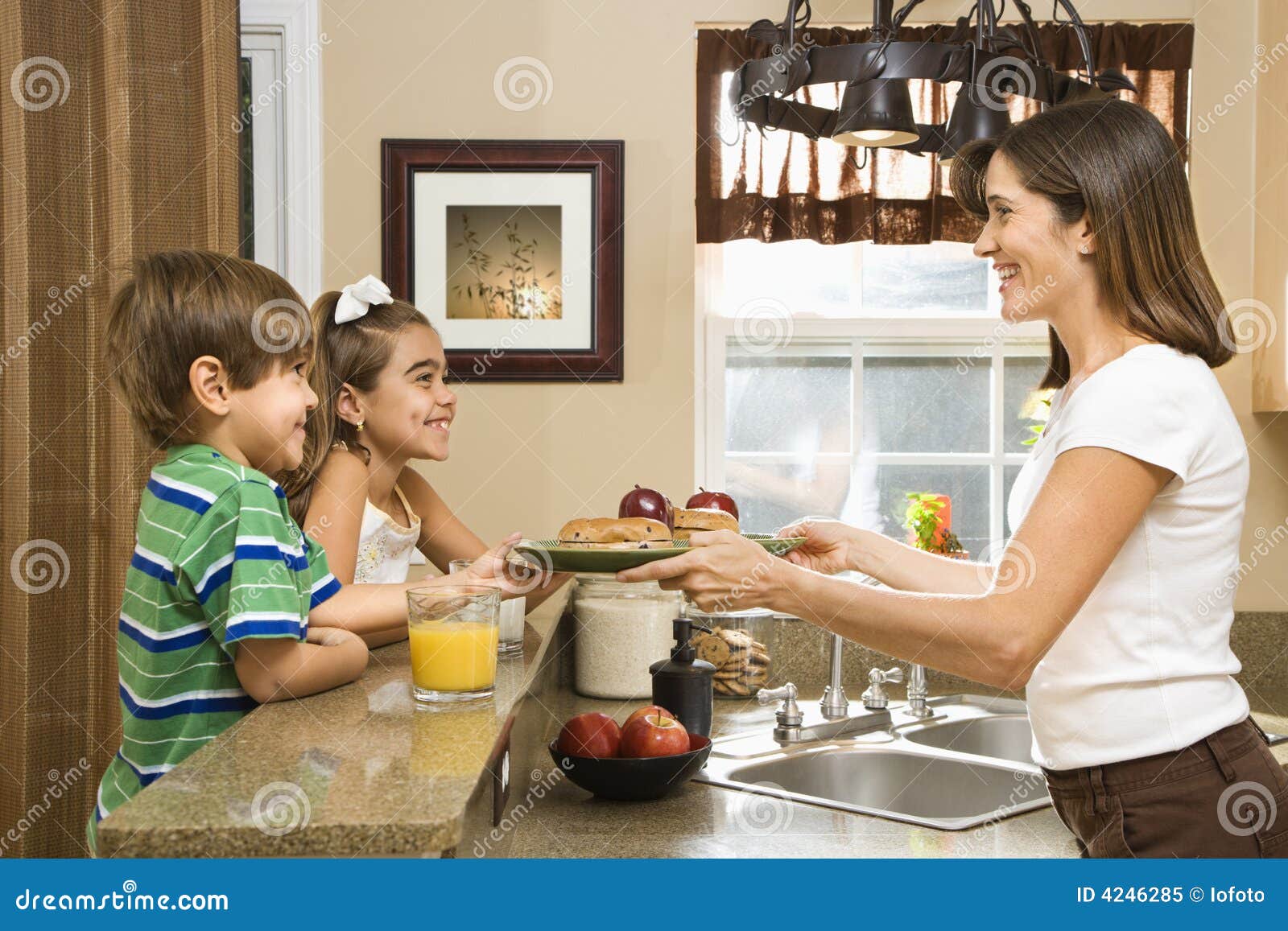Mom giving kids breakfast. stock image. Image of childhood - 4246285