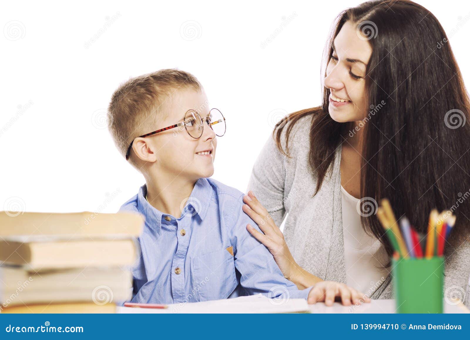 Mom Helps Her Son To Do Homework, Isolated On A White Background ... Mom Helps Her Son To Do Homework, Isolated On A White Background ...