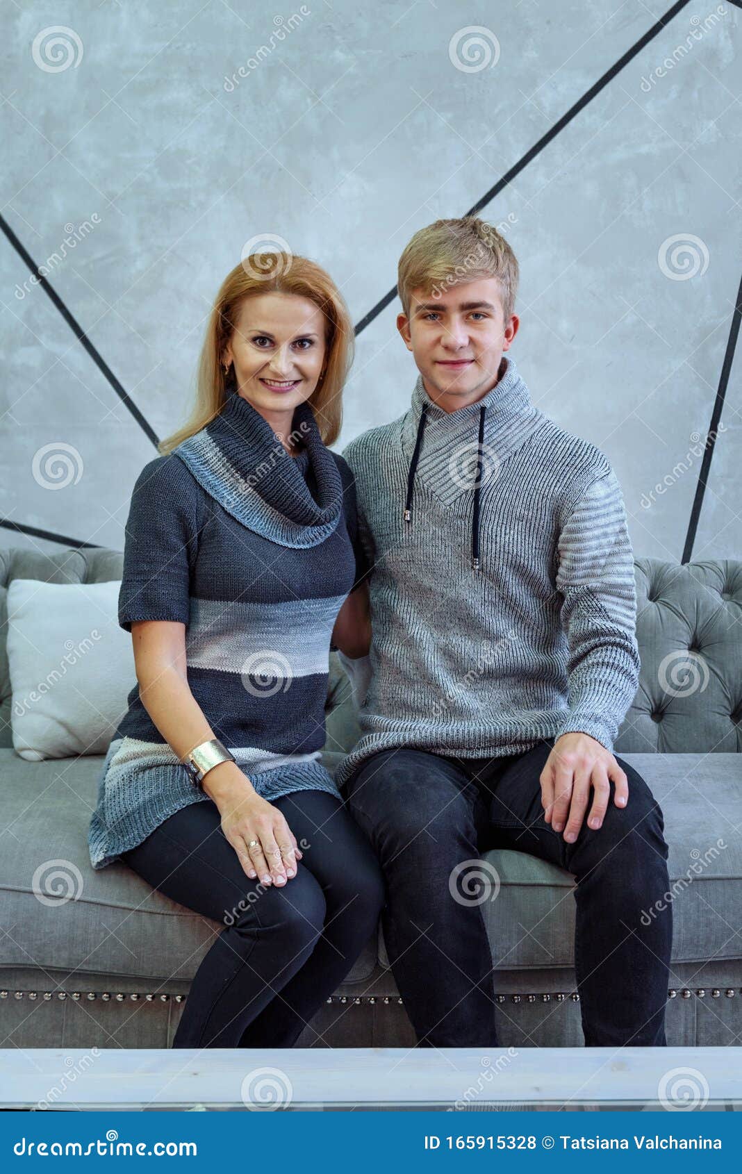 Mom And Son Teenager Are Sitting On The Sofa In The Living Room Stock