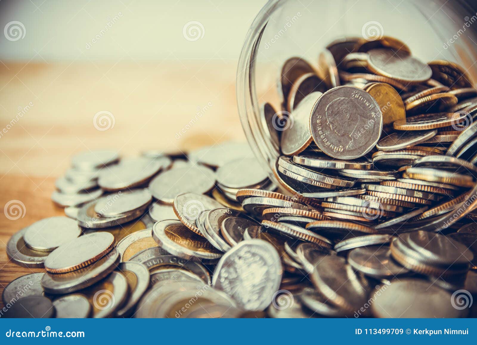 Monedas Que Se Derraman Fuera De Una Botella De Cristal Imagen de ...