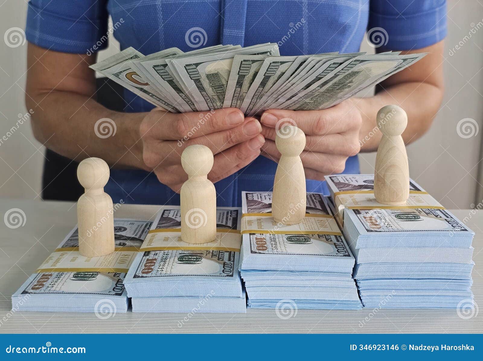 Money Stacking with Wooden Figures Representing Wealth Distribution and ...