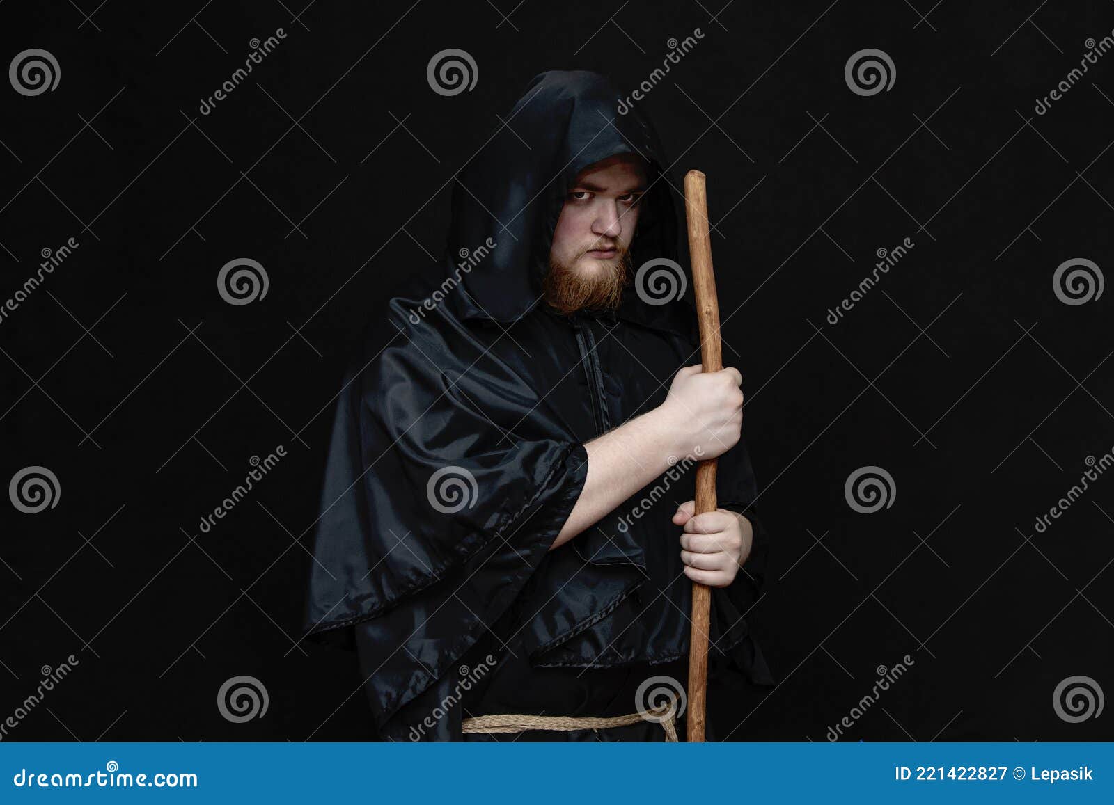 A Monk In A Black Hood With A Staff On A Dark Background, A Gloomy ...