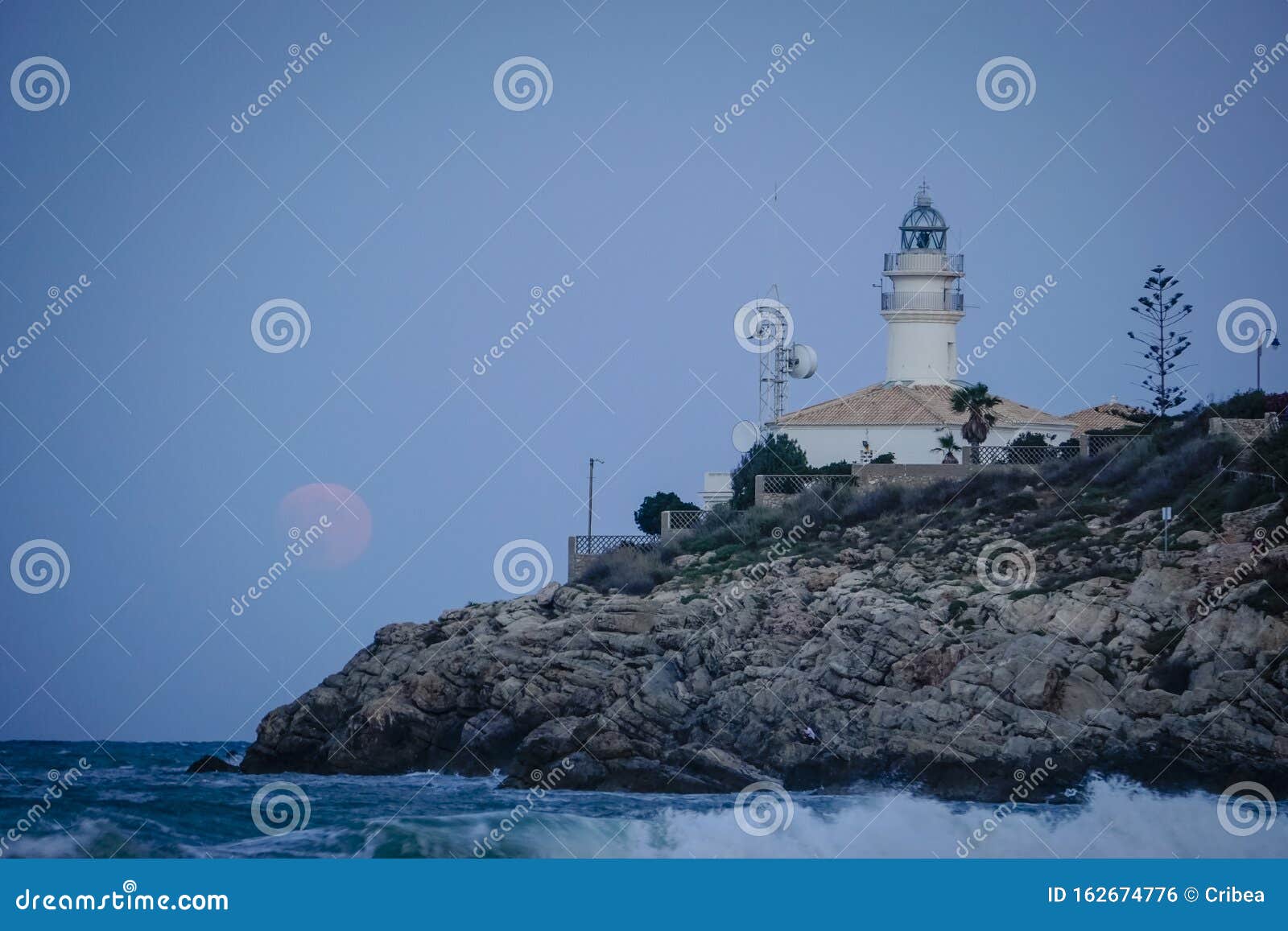Moon Eclipse Over a Lighthouse on the Coast Stock Photo - Image of ...